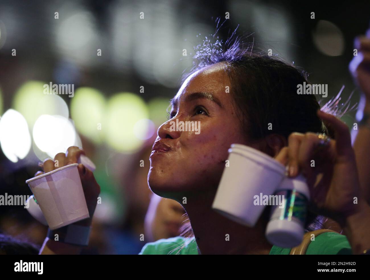 A Filipino woman gargles as she and others attempt to break the ...