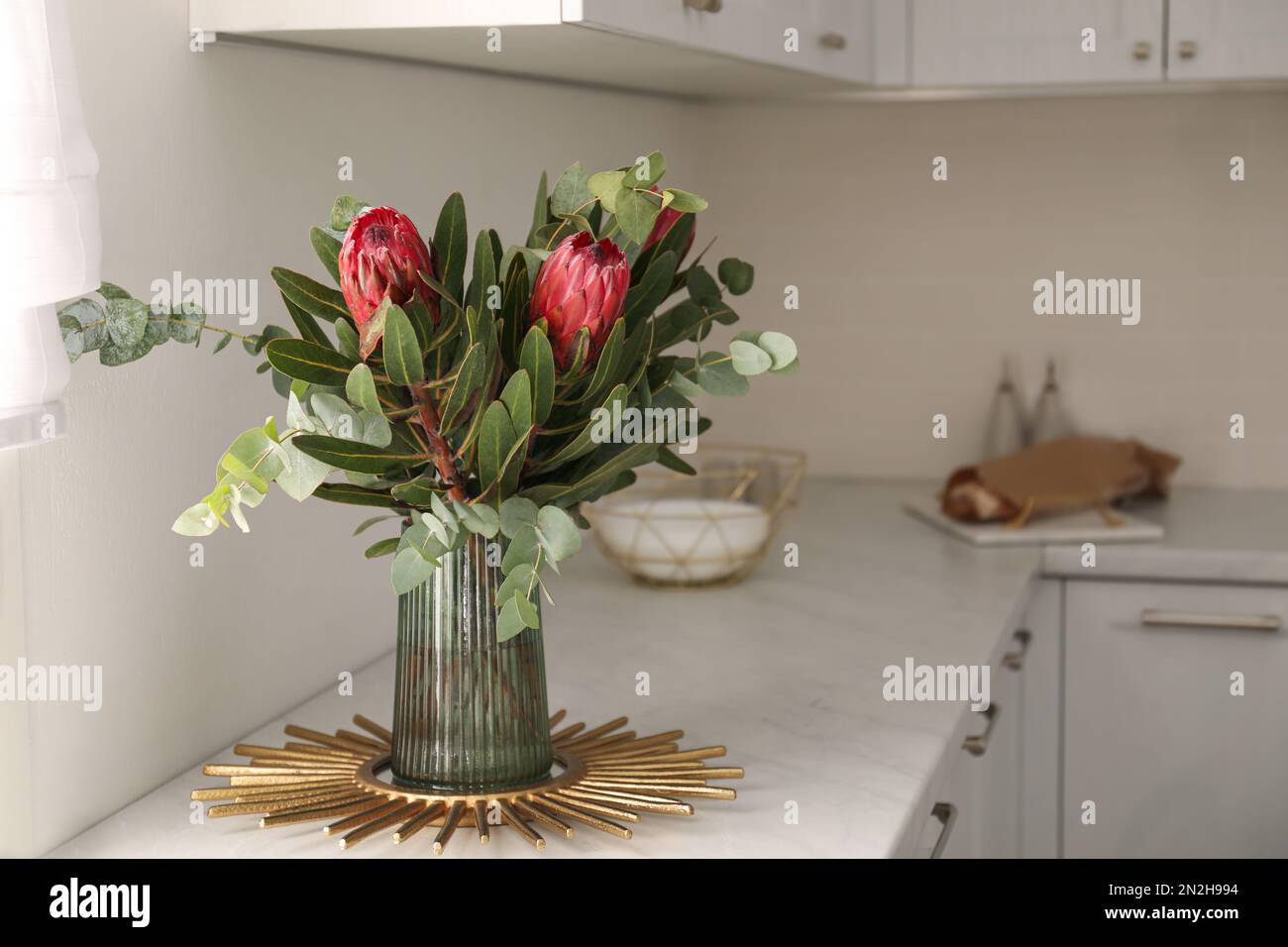 Bouquet with beautiful protea flowers on countertop in kitchen, space ...
