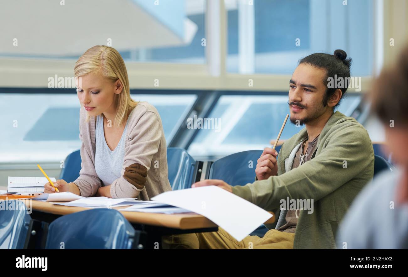 The last exam before the real world begins. A group of students sitting ...