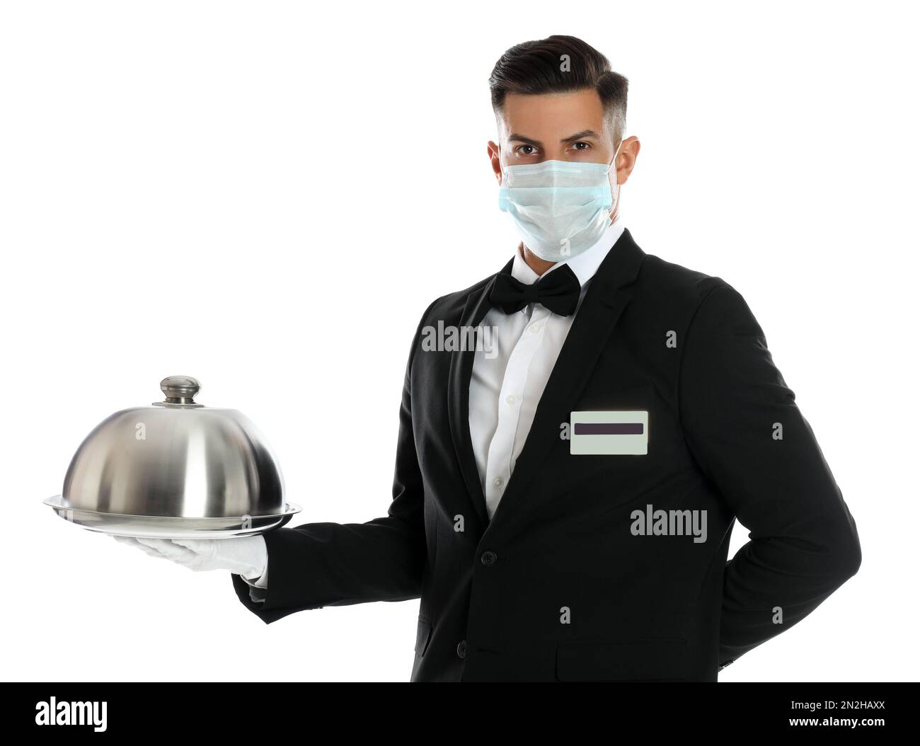 Waiter in medical face mask holding tray with lid on white background ...