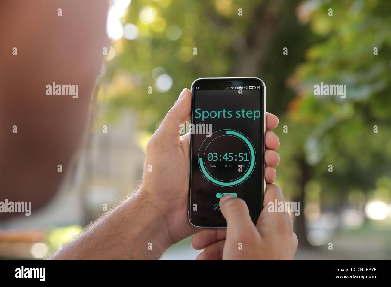 Man using fitness app on smartphone outdoors, closeup Stock Photo - Alamy