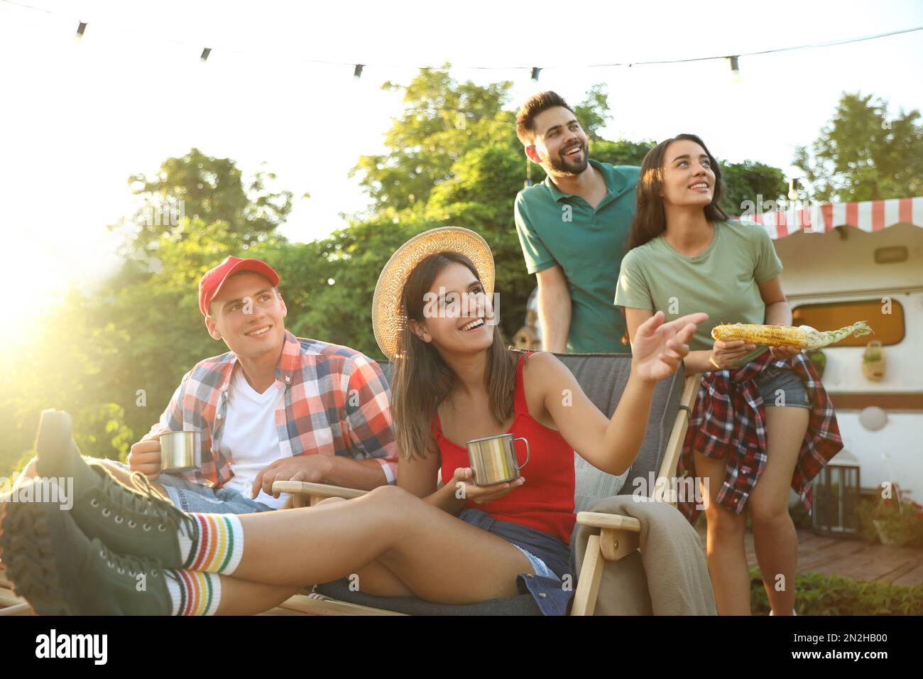 Happy friends resting near motorhome. Camping season Stock Photo - Alamy