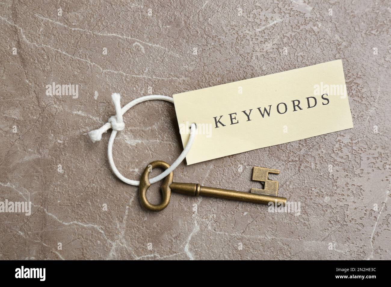 Vintage key and tag wIth word KEYWORDS on grey table, top view Stock ...