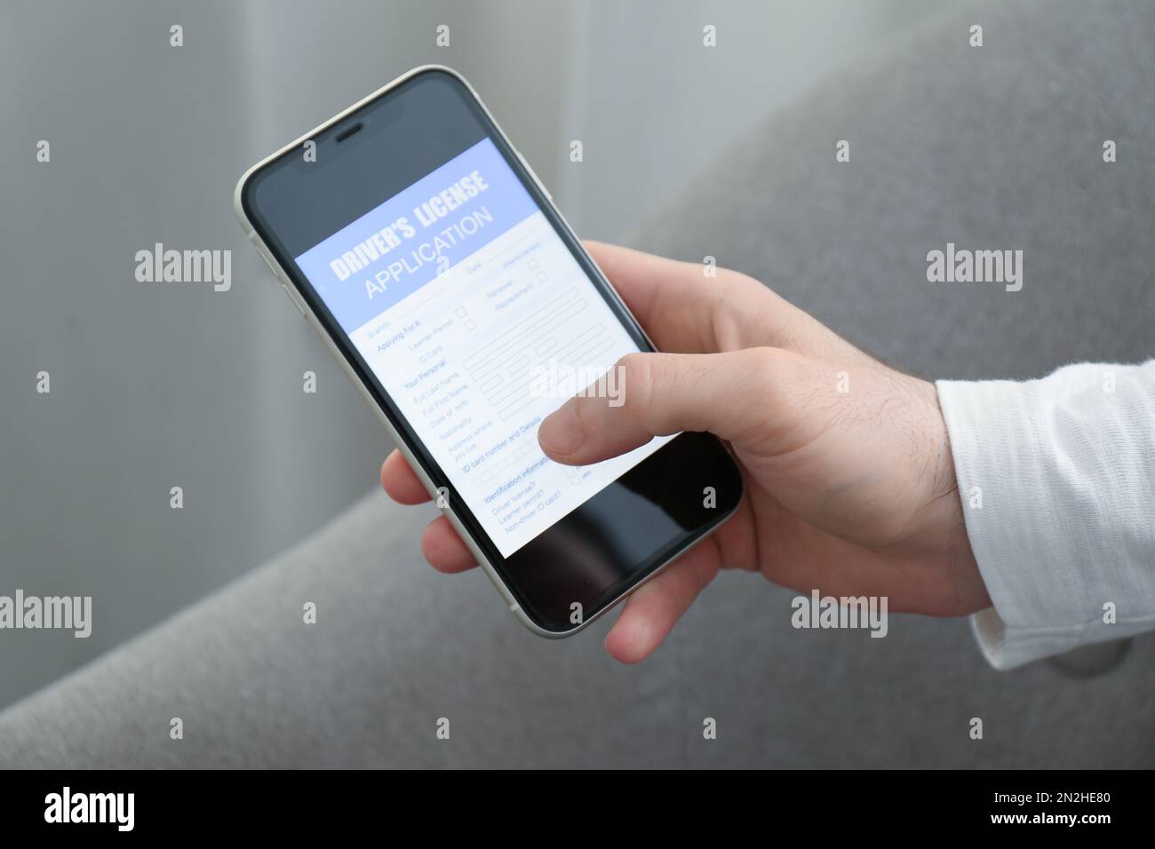 Man holding smartphone with driver's license application form at home, closeup Stock Photo - Alamy
