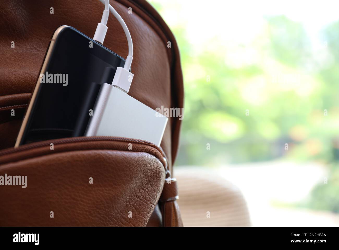 Charging mobile phone with power bank in backpack, closeup. Space for ...