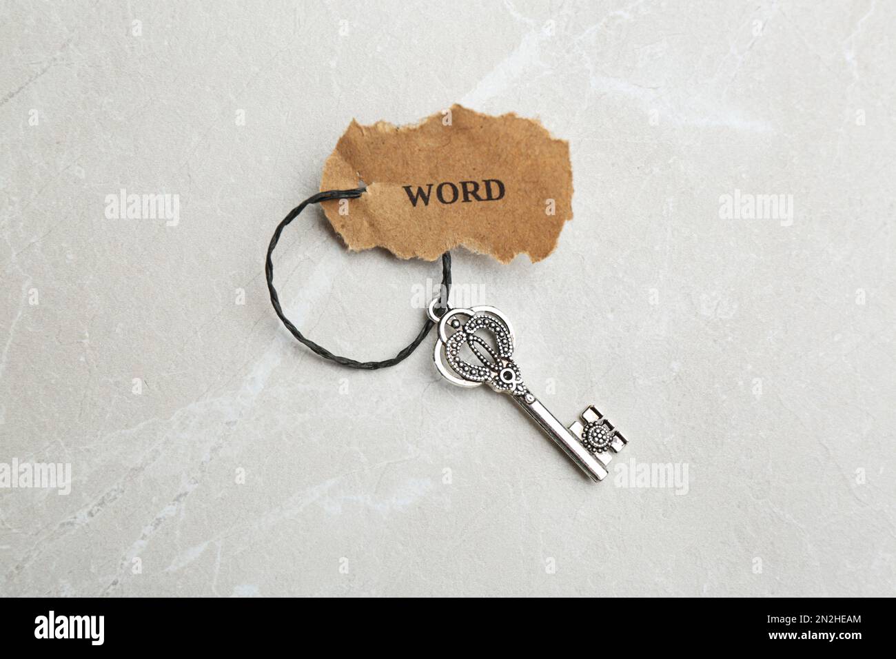 Vintage key with tag on light grey table, top view. Keyword concept ...