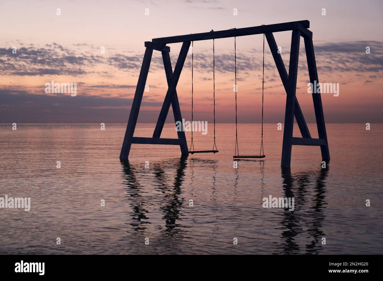 Picturesque view of swing in water on sunrise Stock Photo - Alamy