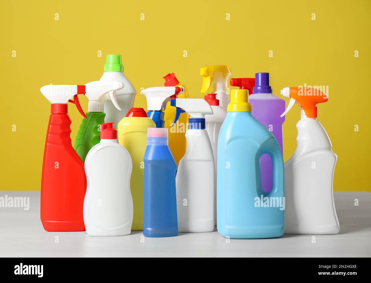 Bottles of different cleaning products on light table Stock Photo - Alamy