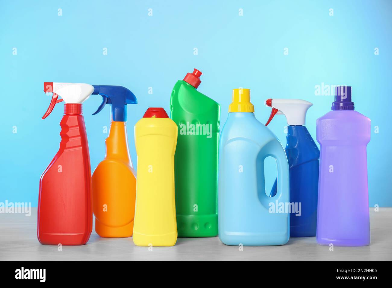 Bottles of different cleaning products on light table Stock Photo - Alamy