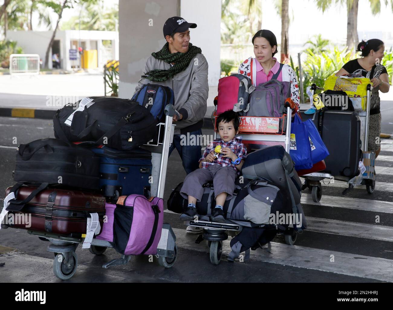 Marie Jean Nasis, center, pushes her cart upon her arrival from Yemen ...