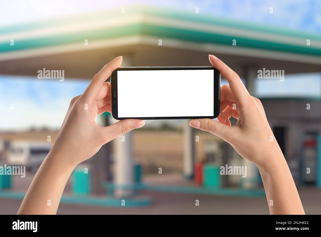 Woman paying for refueling via smartphone at gas station, closeup ...