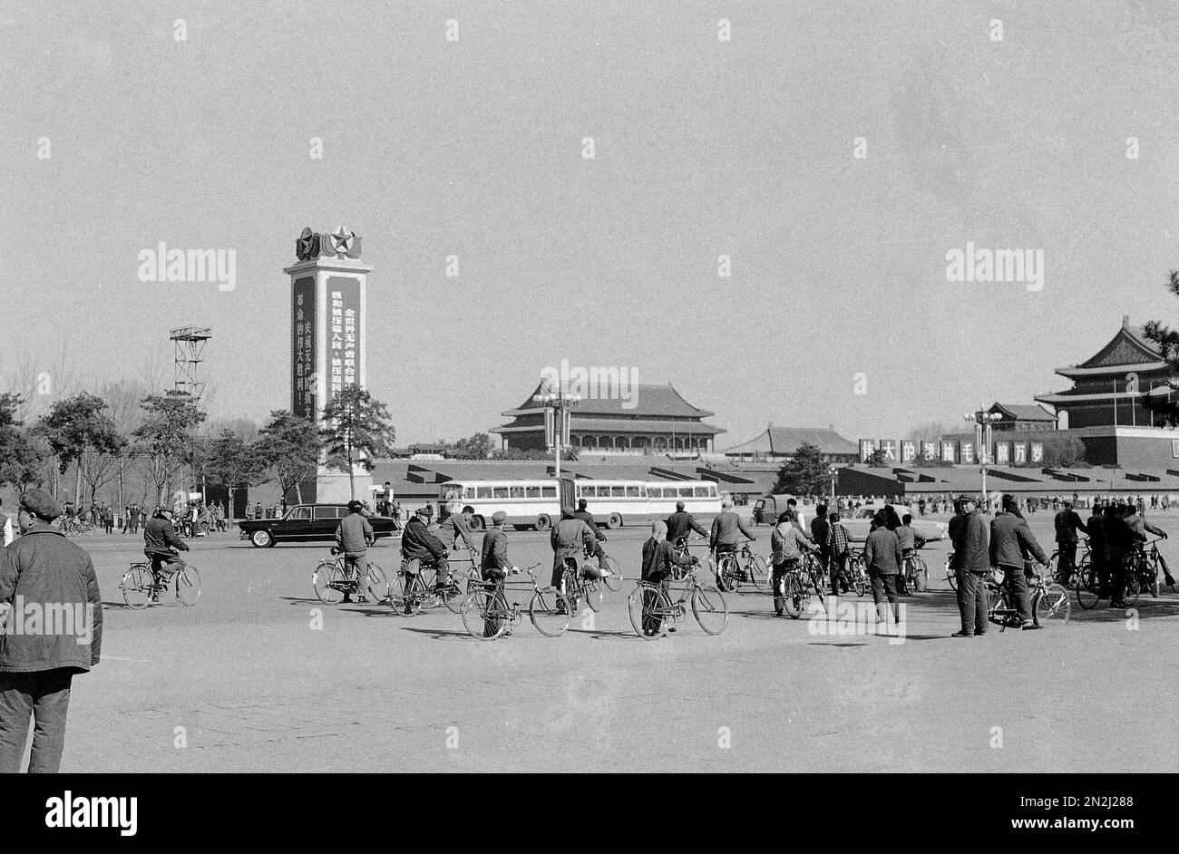 People on bicycles stop in Tiananmen Square in Beijing, China, to watch ...