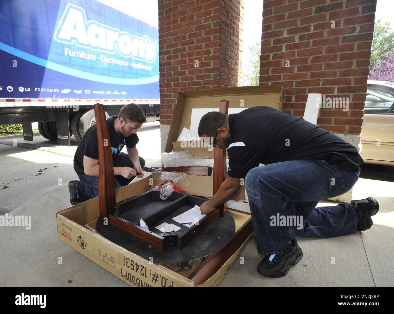 IMAGE DISTRIBUTED FOR AARON'S, INC. - Volunteers assemble a new table ...