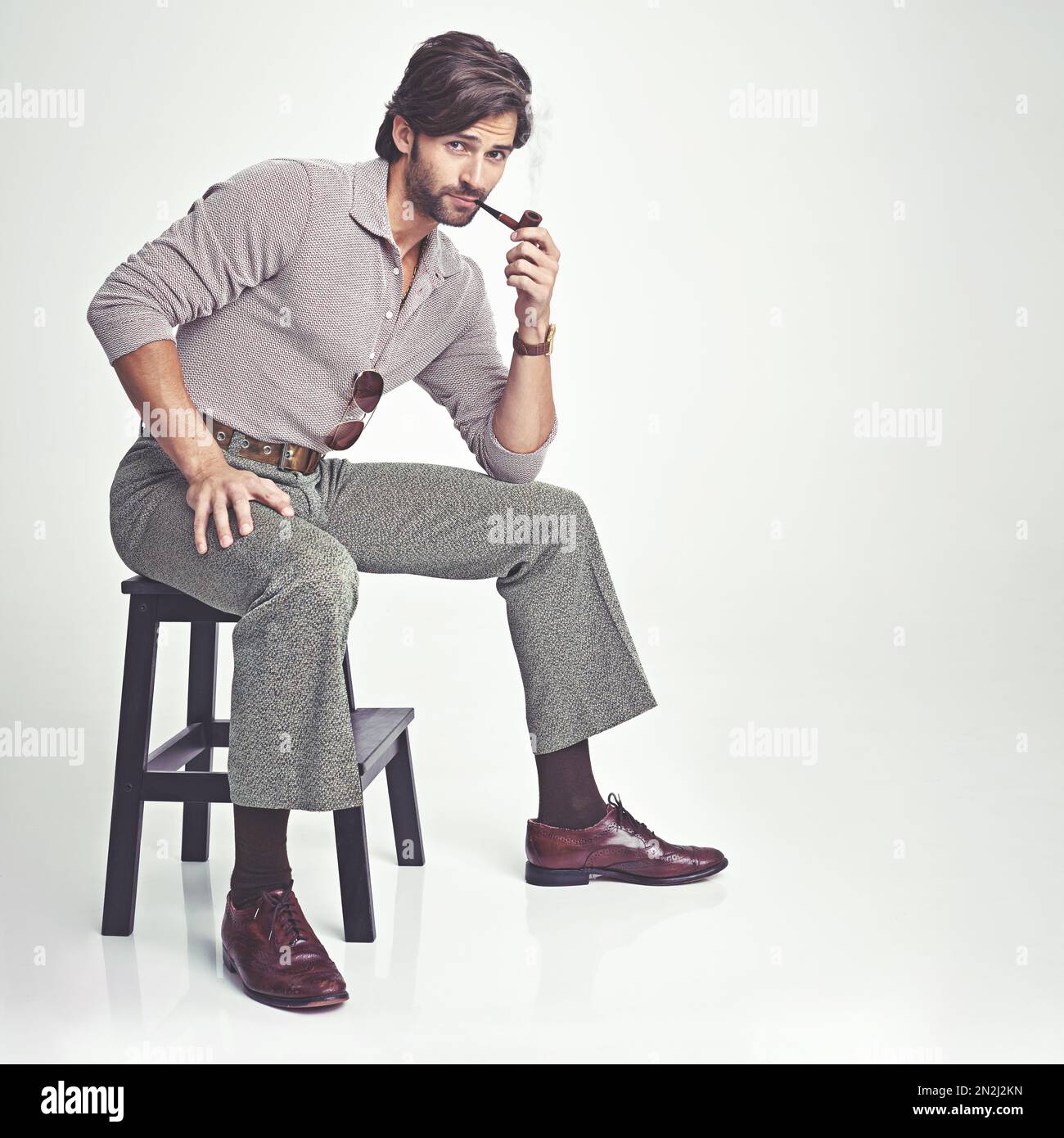 Groovy cool. A young man with 70s style sitting in the studio and ...