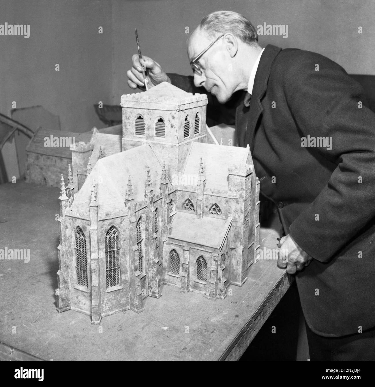 David Harmer is seen working on the roof of his model of the Old Bayham ...