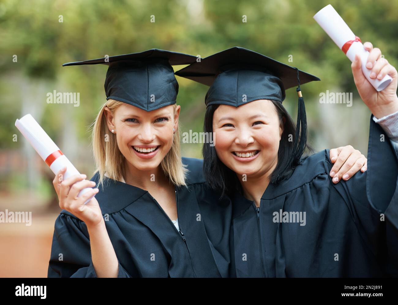 Weve finally graduated. Two young college graduates holding their ...