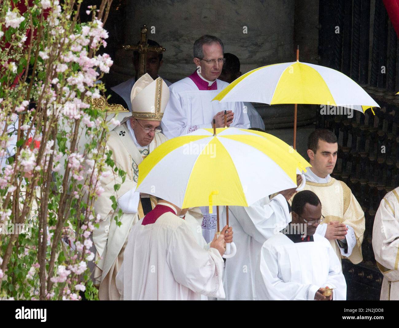 Pope Francis, left, is framed by umbrellas as he celebrates the Easter ...