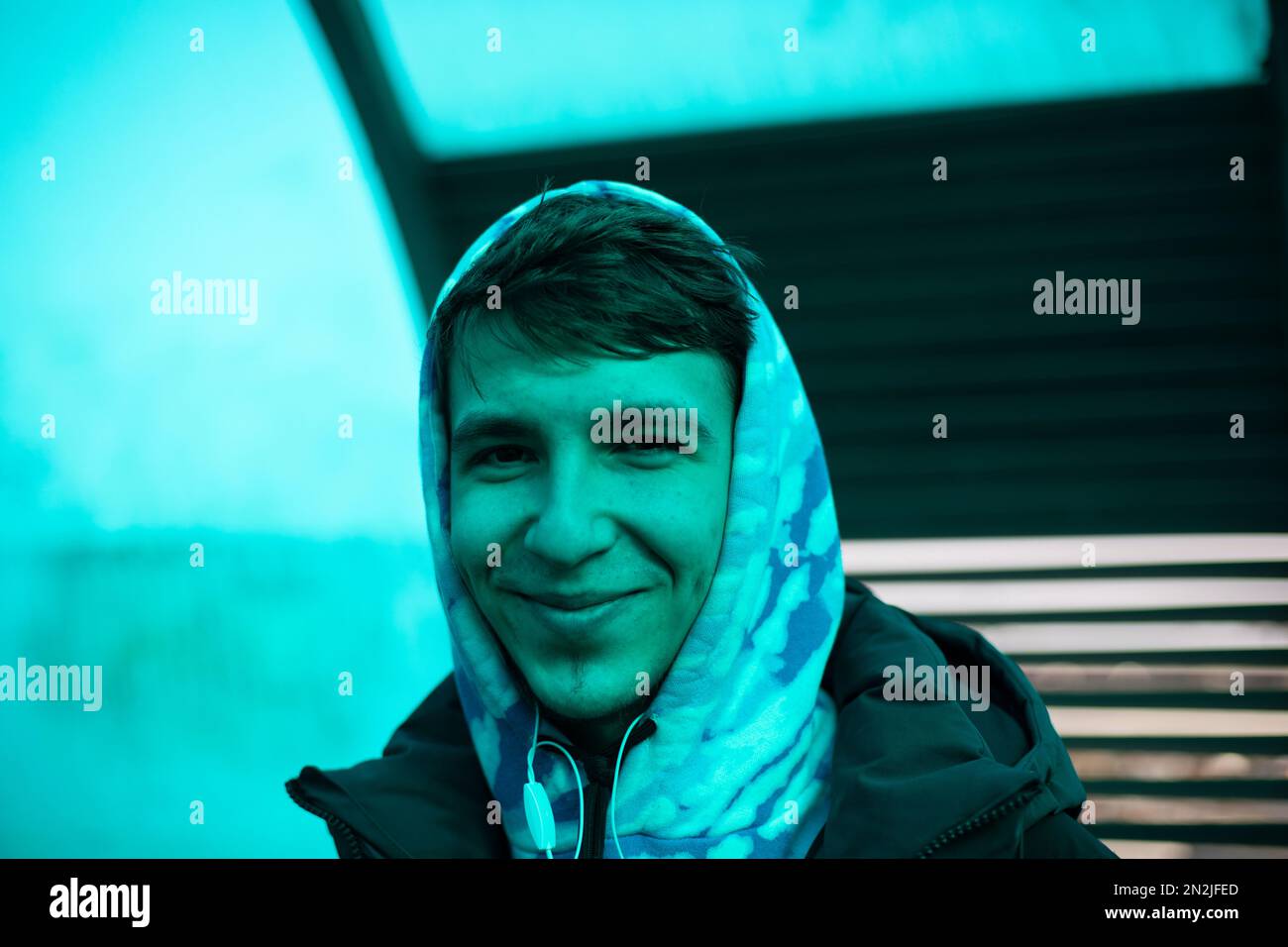 Blue portrait of guy. Man in blue filter. Student in hood. Smiling guy ...