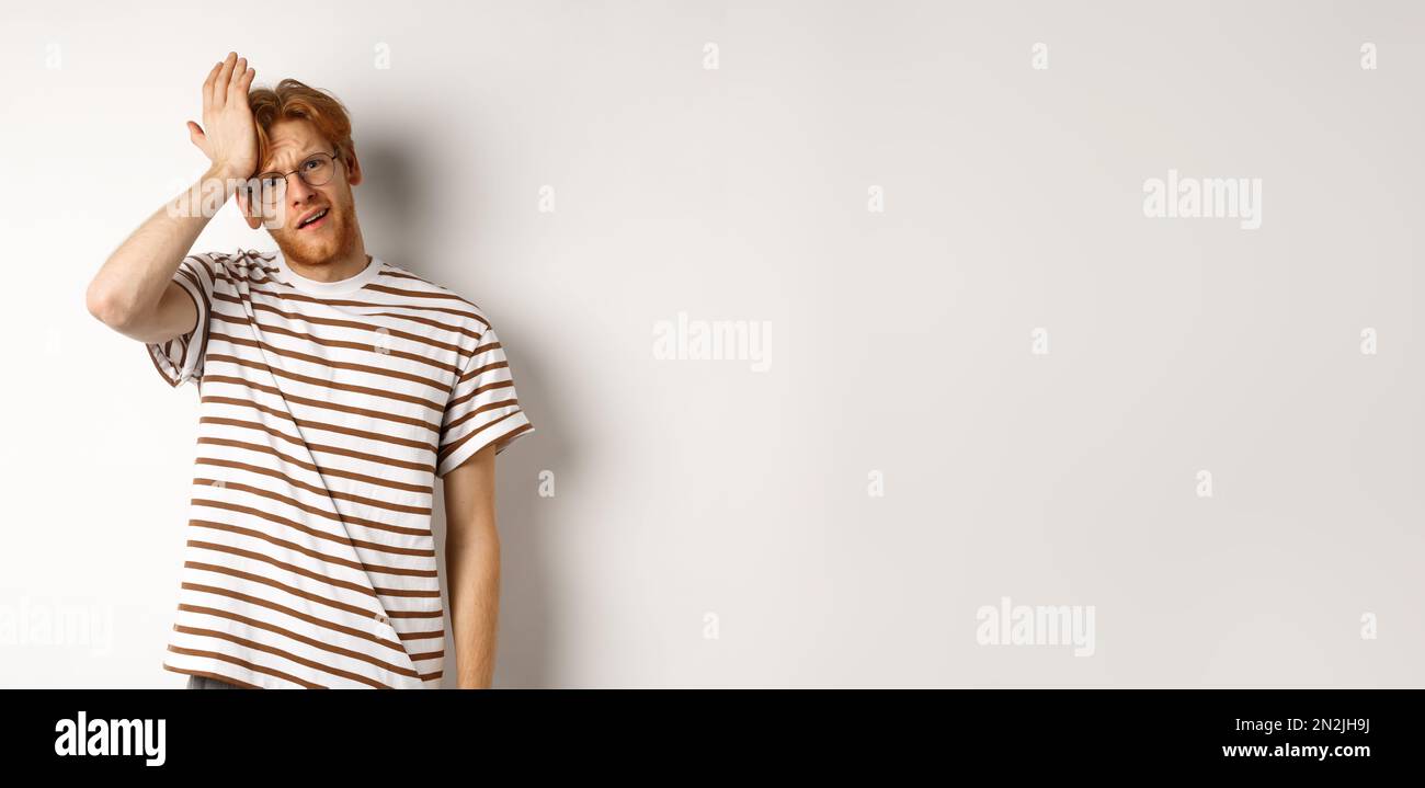 Tired and distressed redhead male student slap forehead, making ...