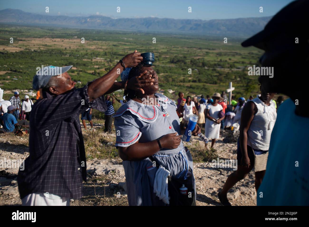 A man splashes 'holy water' on the face of a woman during a Good Friday ...