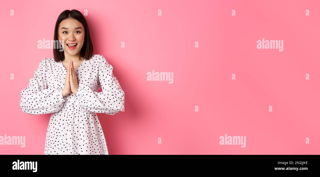 Beautiful asian woman thanking you, holding hands together in ...