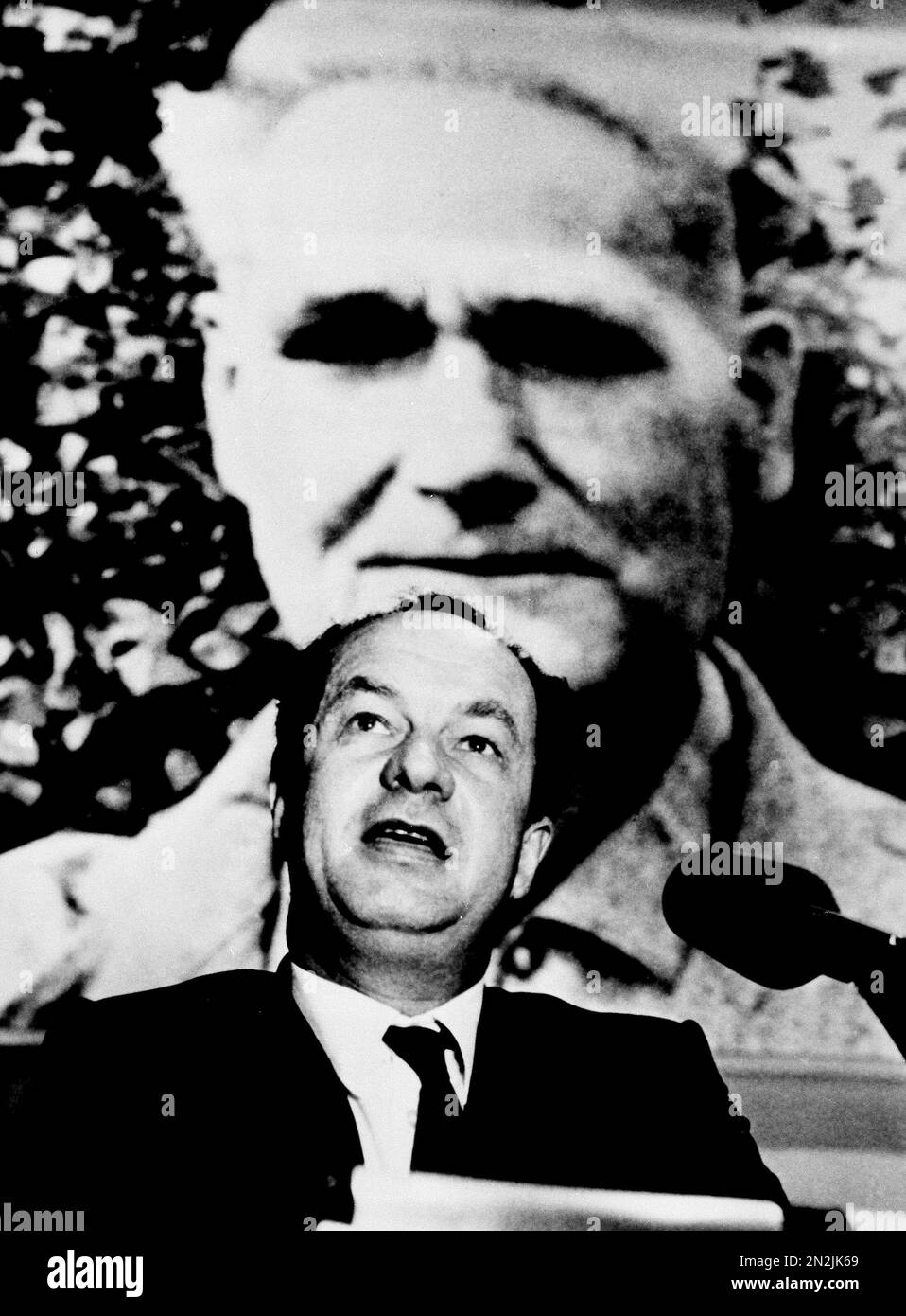 Dwarfed by a huge photograph of his father Rudolf Hess, Wolf Ruediger Hess, shown speaking, July ...