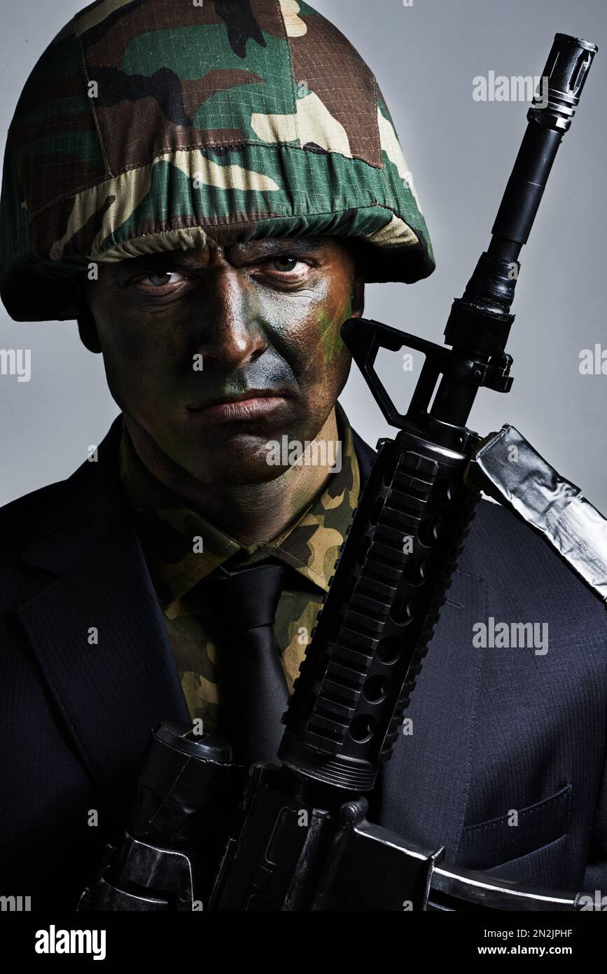 Ready for a battle. A young military man wearing camouflage facepaint ...