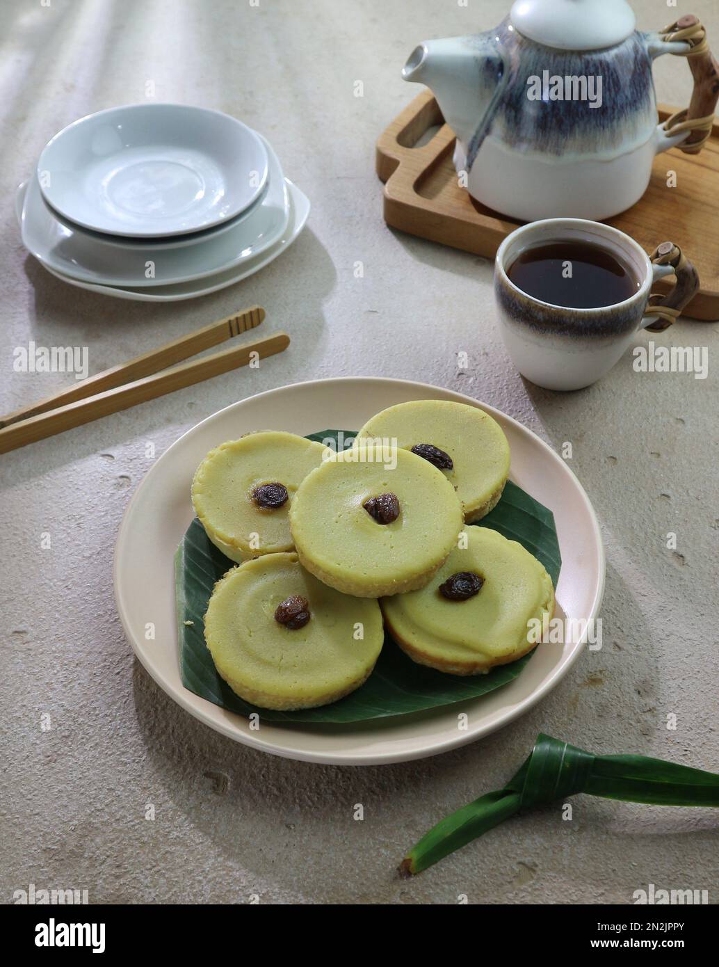serving of potato cakes with raisins and pandan leaves decoration Stock ...