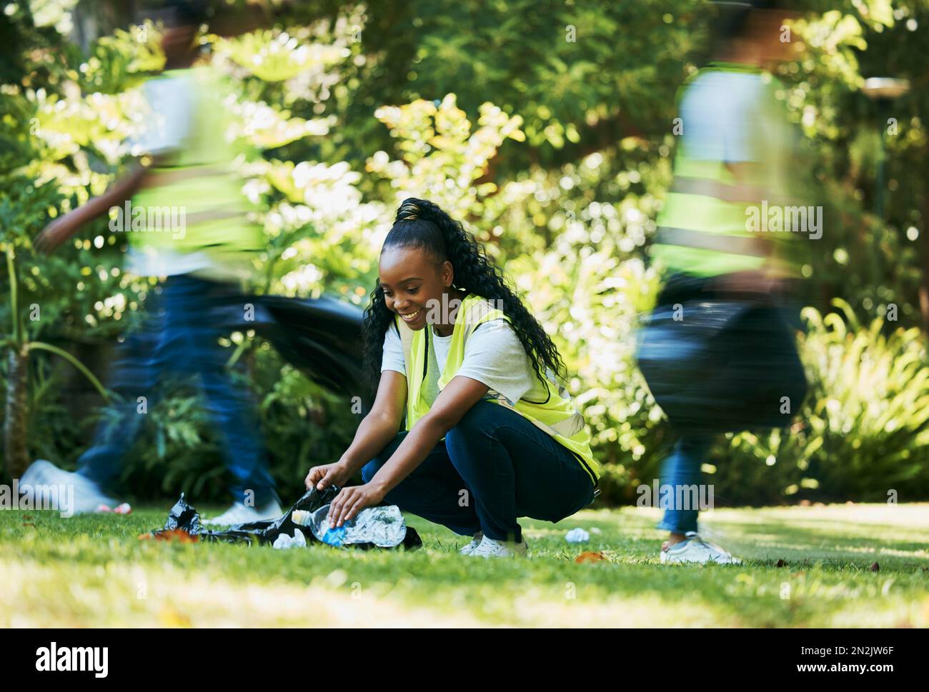 Volunteer, plastic and black woman cleaning park as community service ...