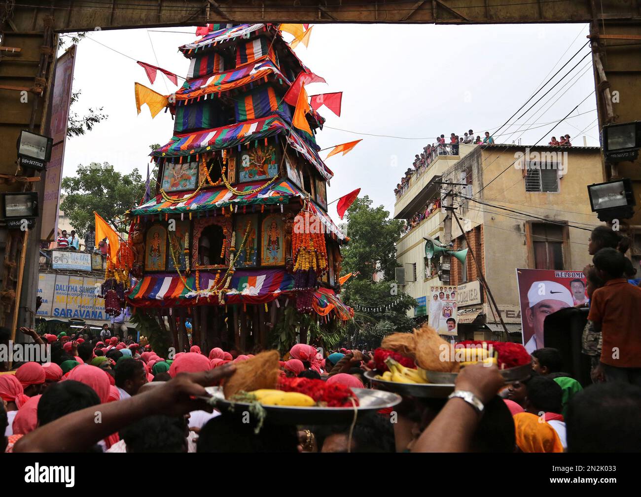 Indian devotees wait with offerings as the chariot carrying an idol of ...