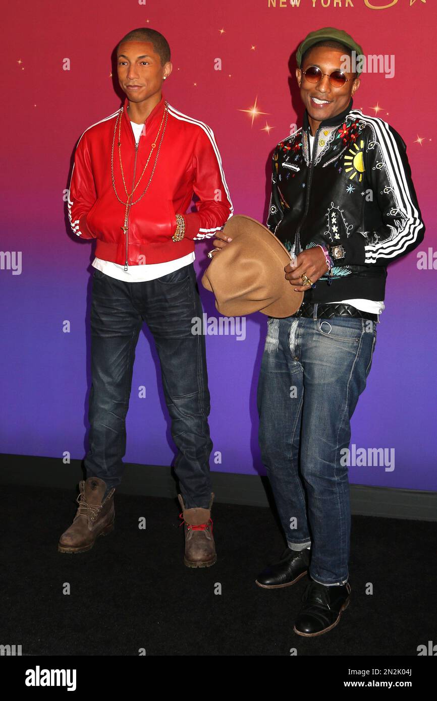Recording artist and producer Pharrell Williams, right, unveils his wax ...