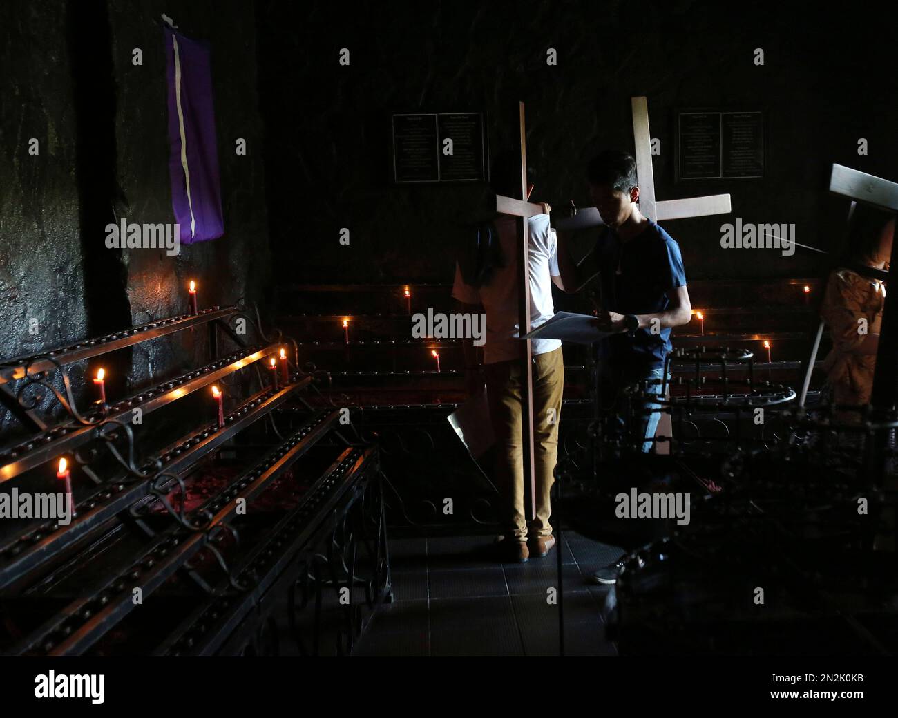 Filipino devotees carry wooden crosses as they make the Stations of the ...