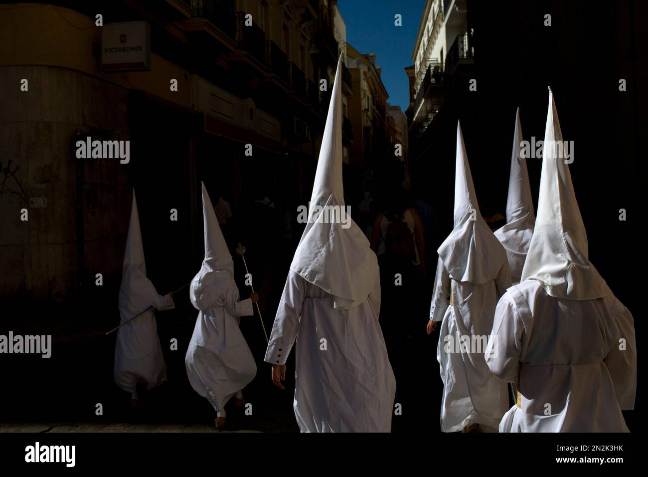 Hooded penitents from the "La Candelaria" brotherhood walk to church to ...