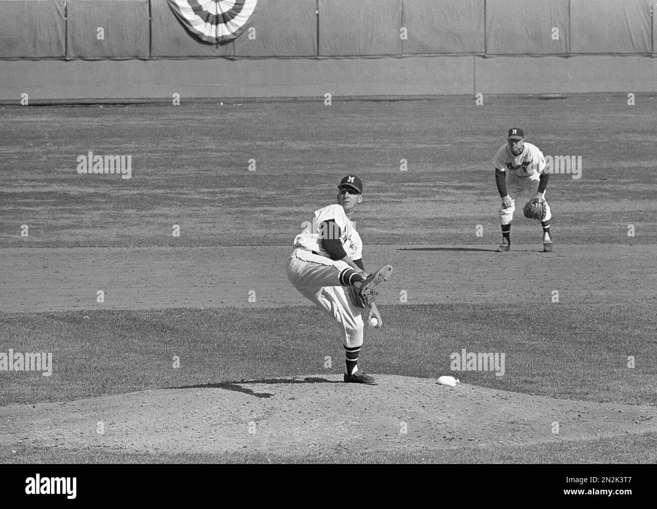 Warren Spahn Milwaukee Braves, kicks as he starts a pitch in the game ...