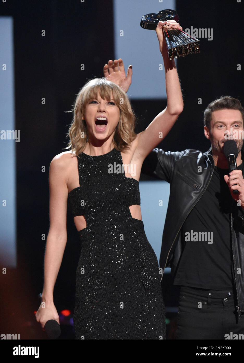 Taylor Swift, left, accepts the award for artist of the year and Ryan ...