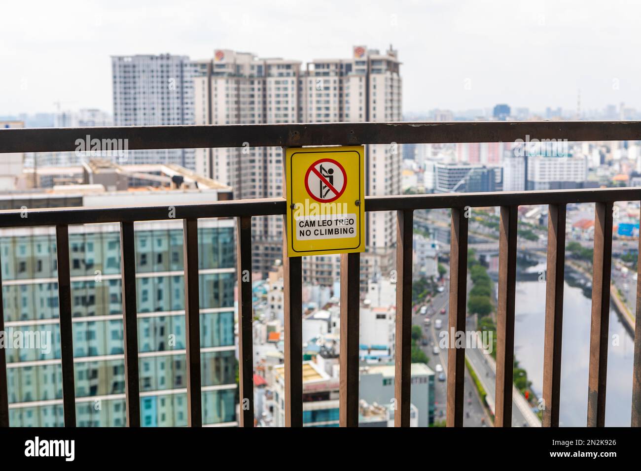 A No Climbing sign on the fence on top of a tower block in Ho Chi Minh ...