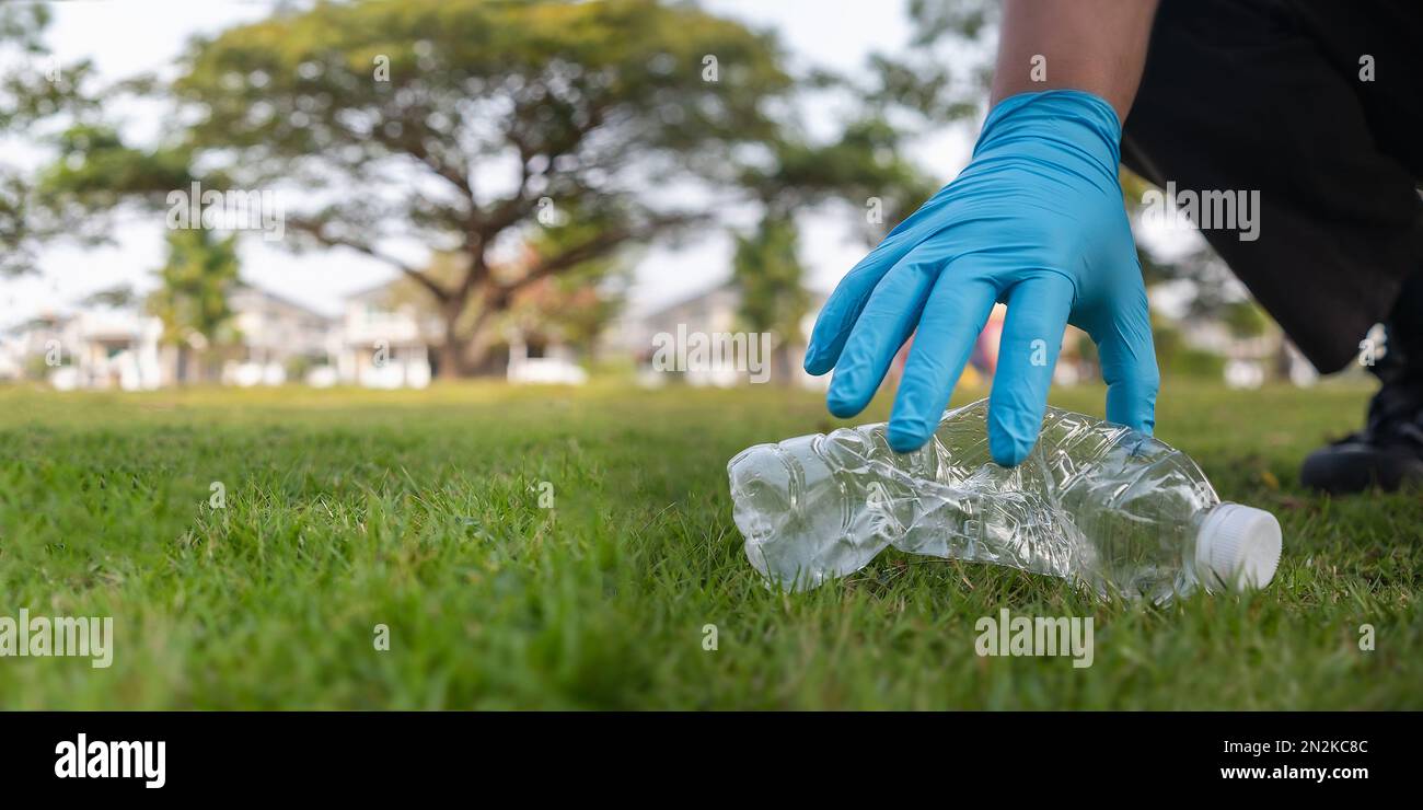 Volunteer man collecting trash and reusing plastic cleanup to recycle ...