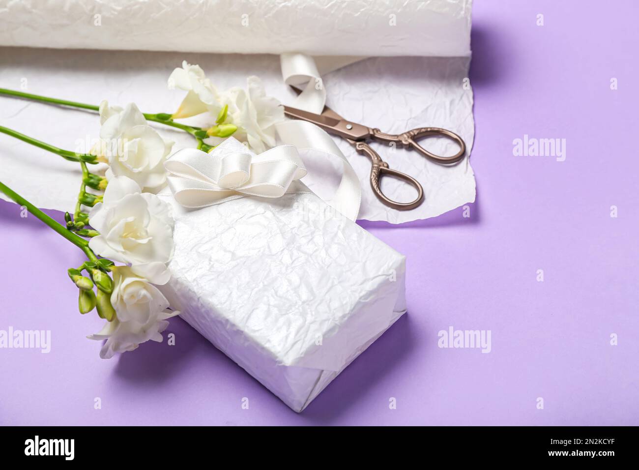Composition with beautiful gift box, freesia flowers, scissors and ...