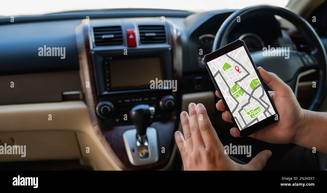 A man makes use of GPS and the internet. online map in the car controls ...