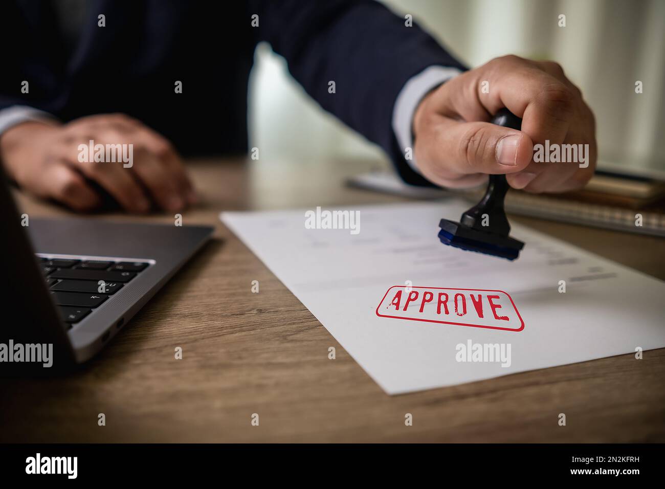 man stamping approval Text is approved by stamping the document on ...
