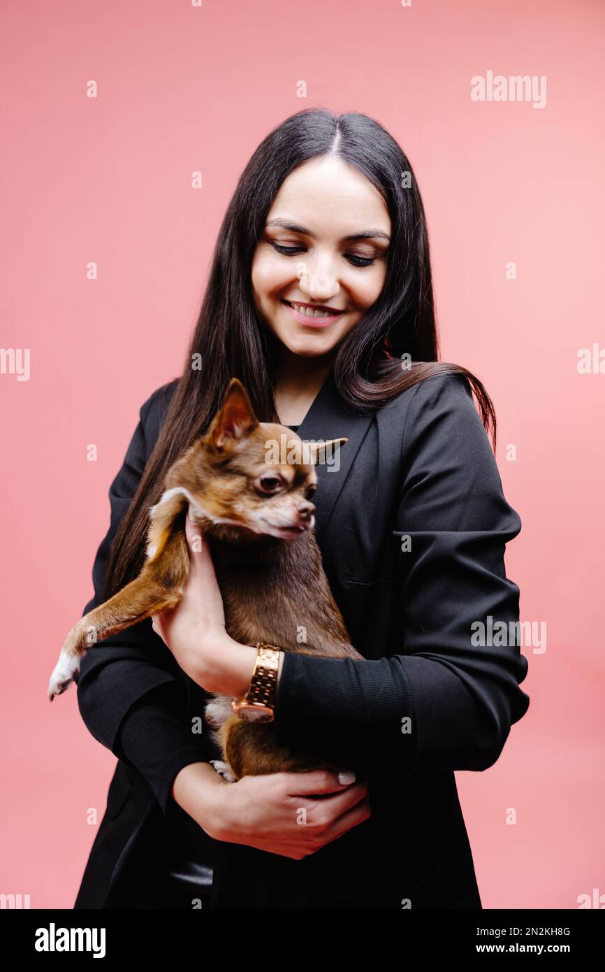 Wonderful european female model chilling in studio with puppy. Indoor ...