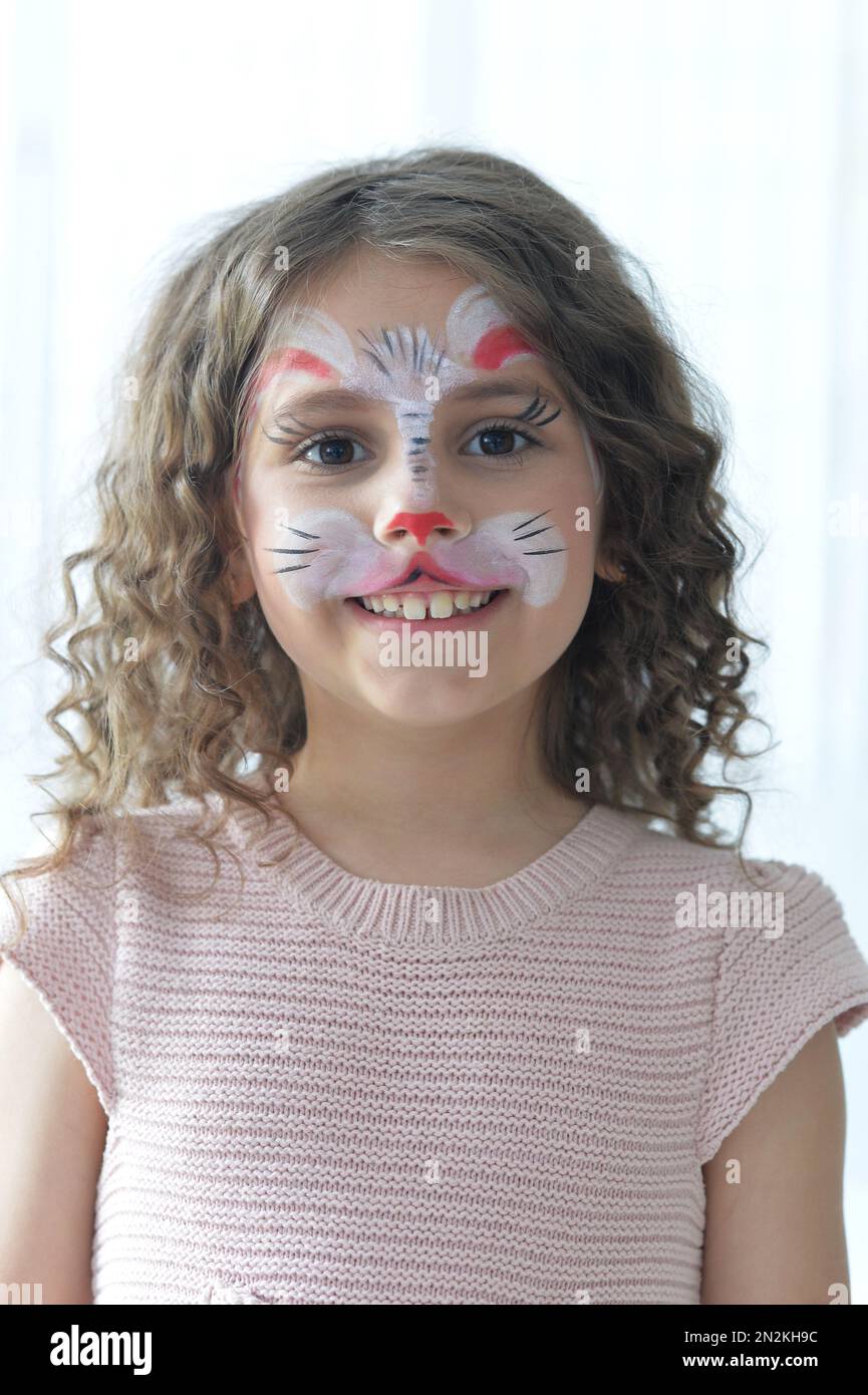 Cute girl with face painted as rabbit posing Stock Photo - Alamy