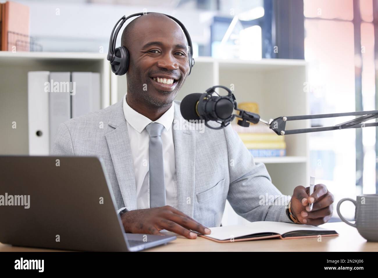 Portrait, laptop and radio with a black man presenter writing in a ...