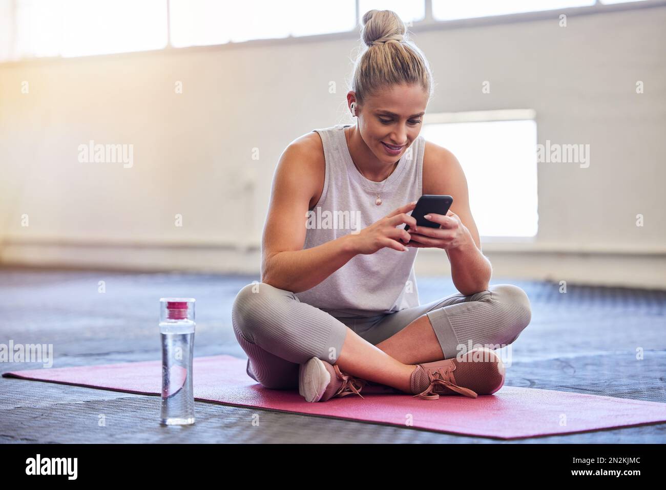Exercise, relax and woman with phone on floor reading email or text ...