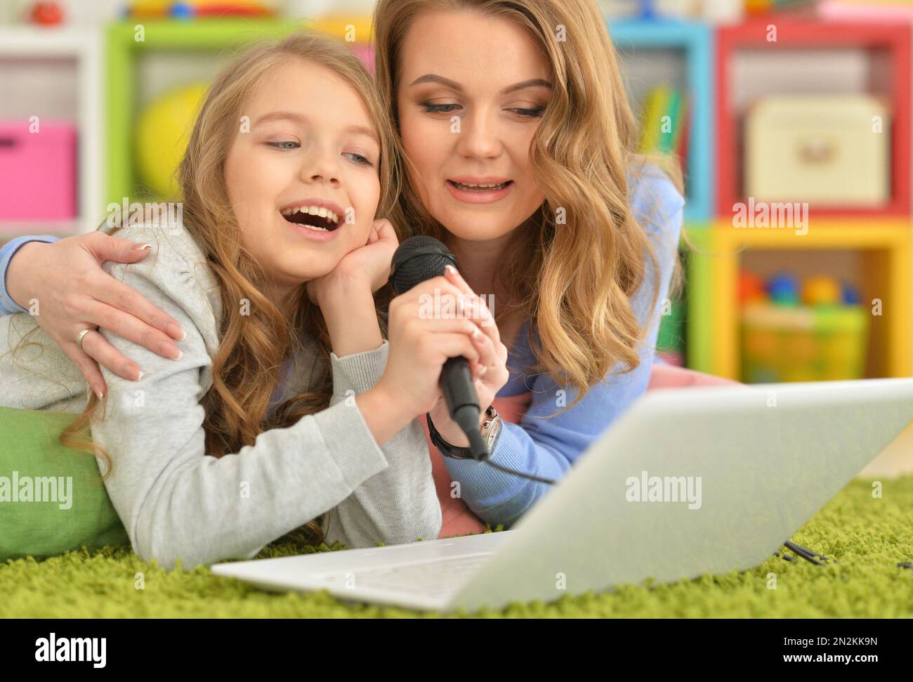 mother and daughter singing karaoke Stock Photo - Alamy