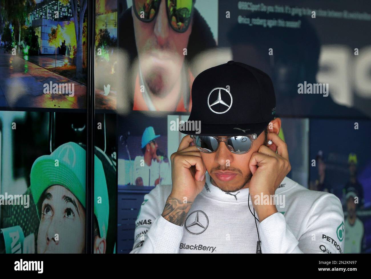 Mercedes driver Lewis Hamilton of Britain puts his fingers in his ears ...