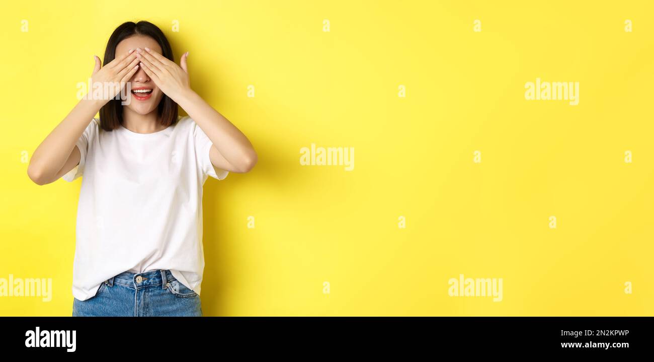 Happy asian woman waiting for surprise gift, close eyes and smiling ...