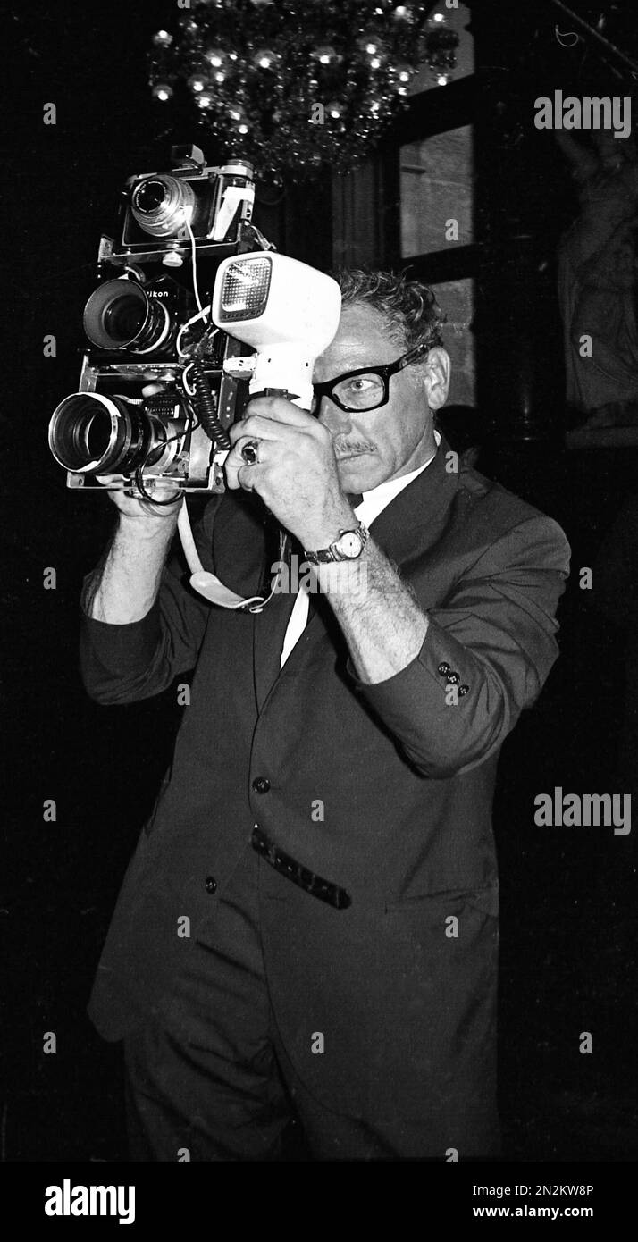 A photographer holds three cameras at the Hotel de Ville in Paris ...