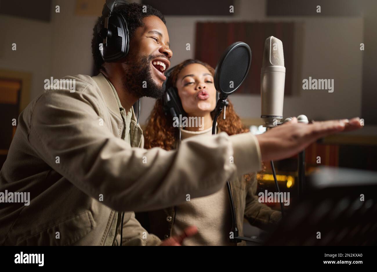 Music, man and woman recording in studio in home, singing into ...