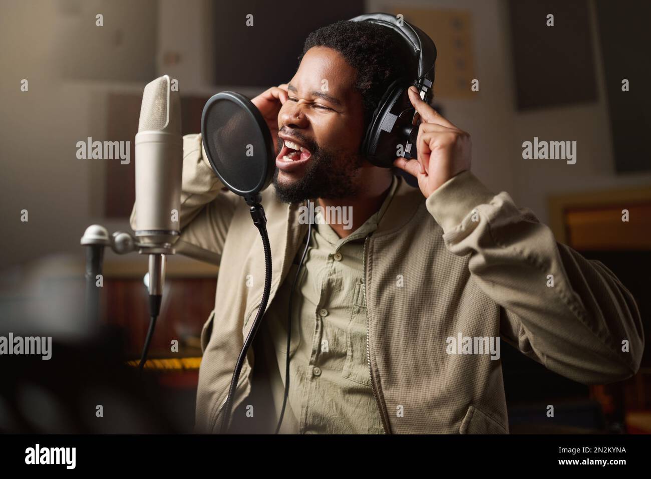 Music, streaming and man recording in studio in home, singing into ...